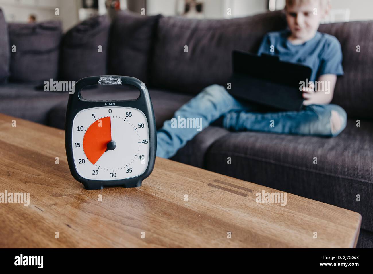 Boy spending time with laptop according to clock Stock Photo - Alamy