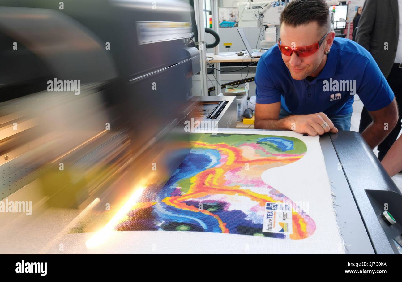 Chemnitz, Germany. 09th May, 2022. A printer dyes a textile surface at ...