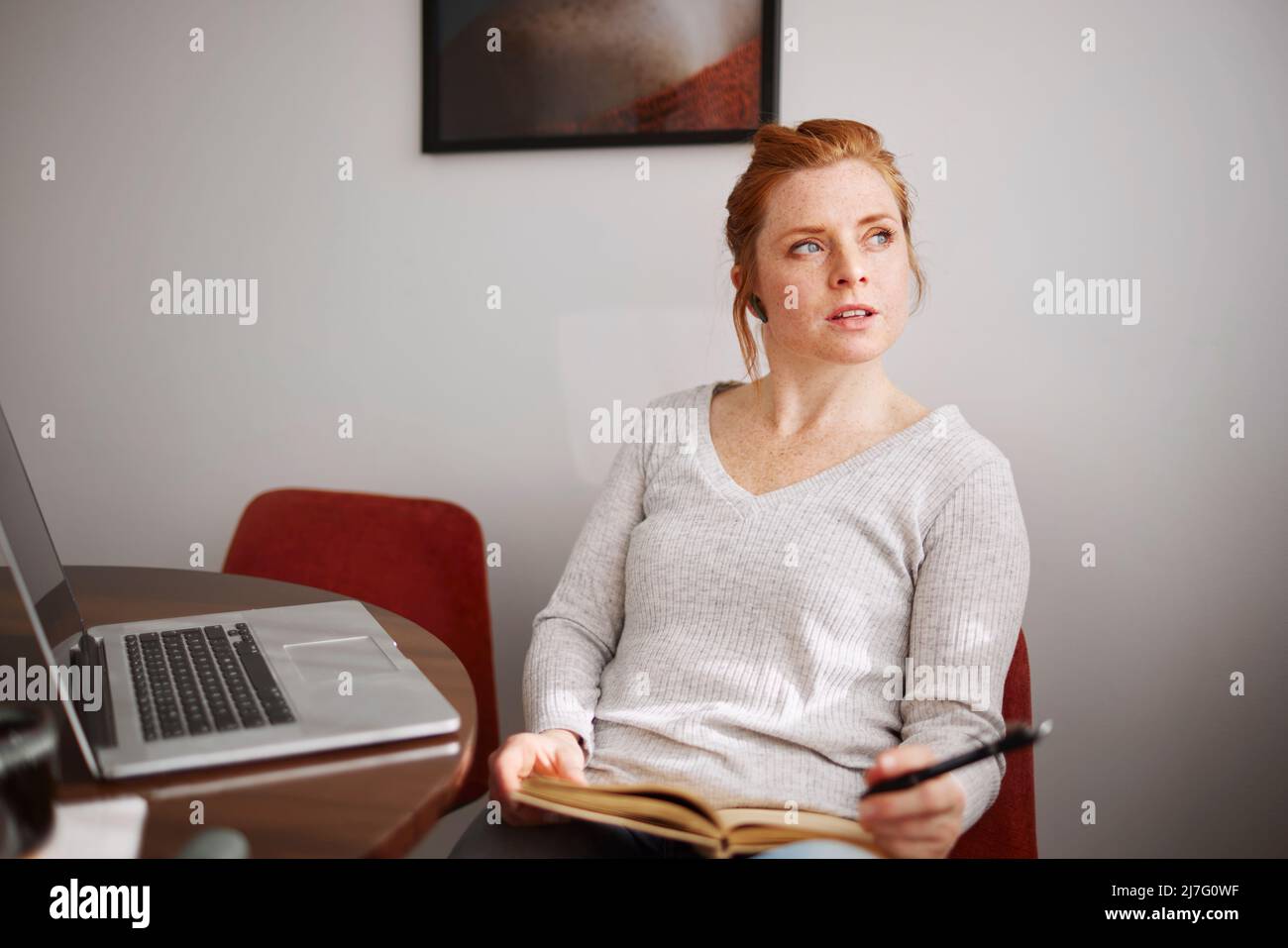 Woman in front of laptop looking away Stock Photo - Alamy