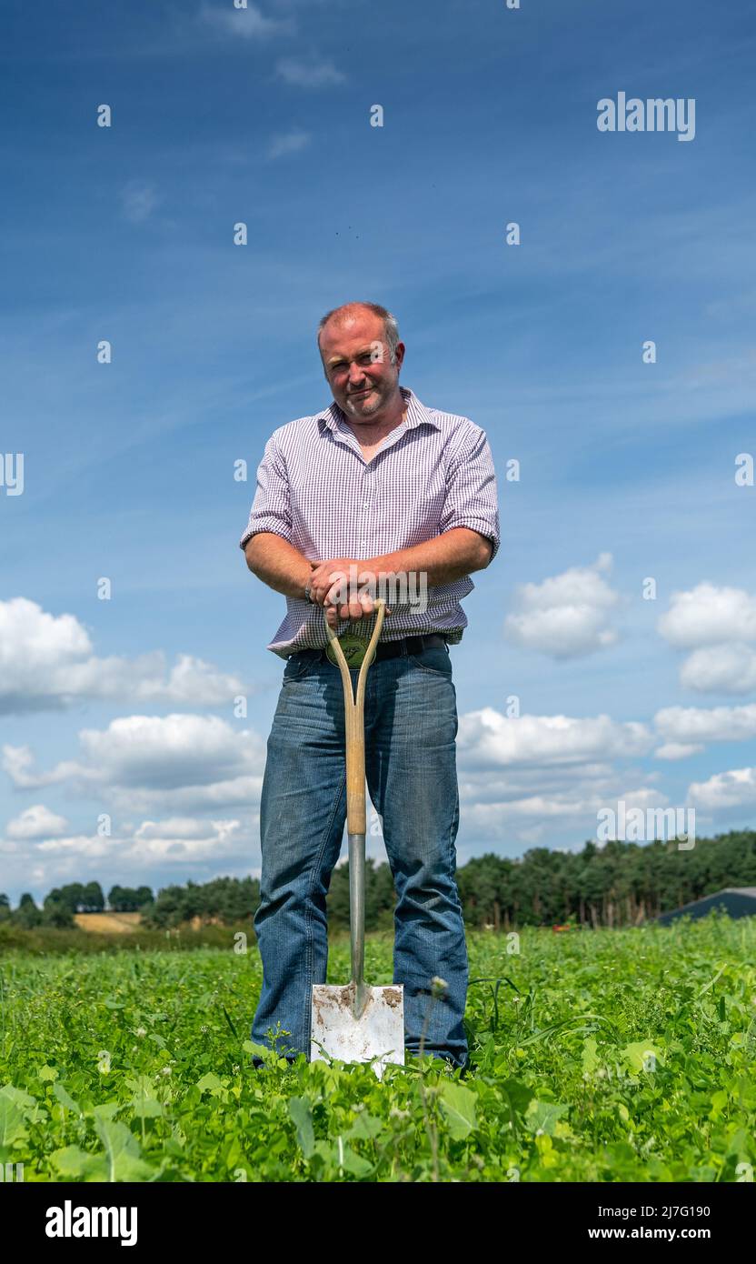 Farmer stood in his field leaning on a spade. Durham, UK Stock Photo ...