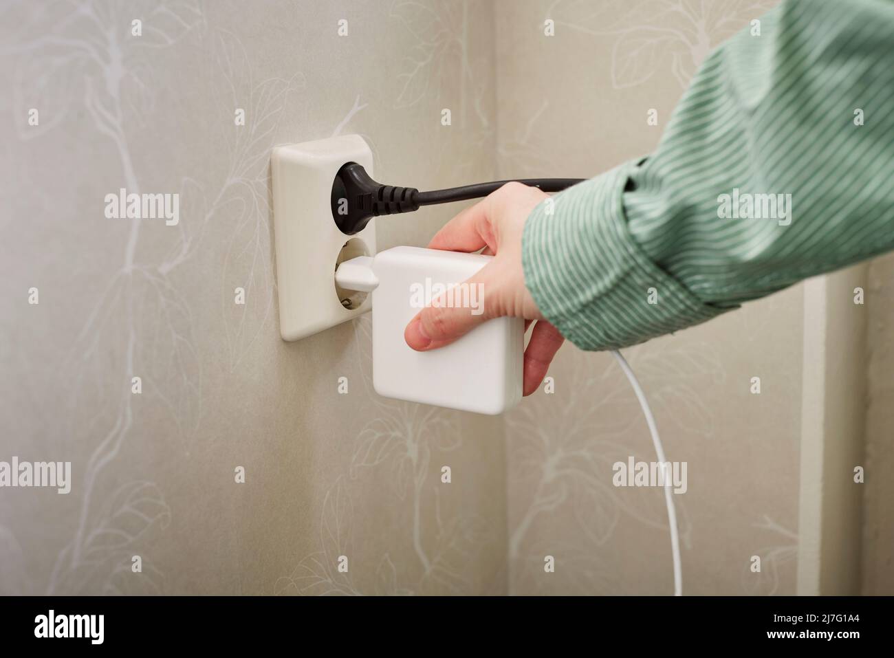 Hand plugging in or out electric cord into socket Stock Photo - Alamy