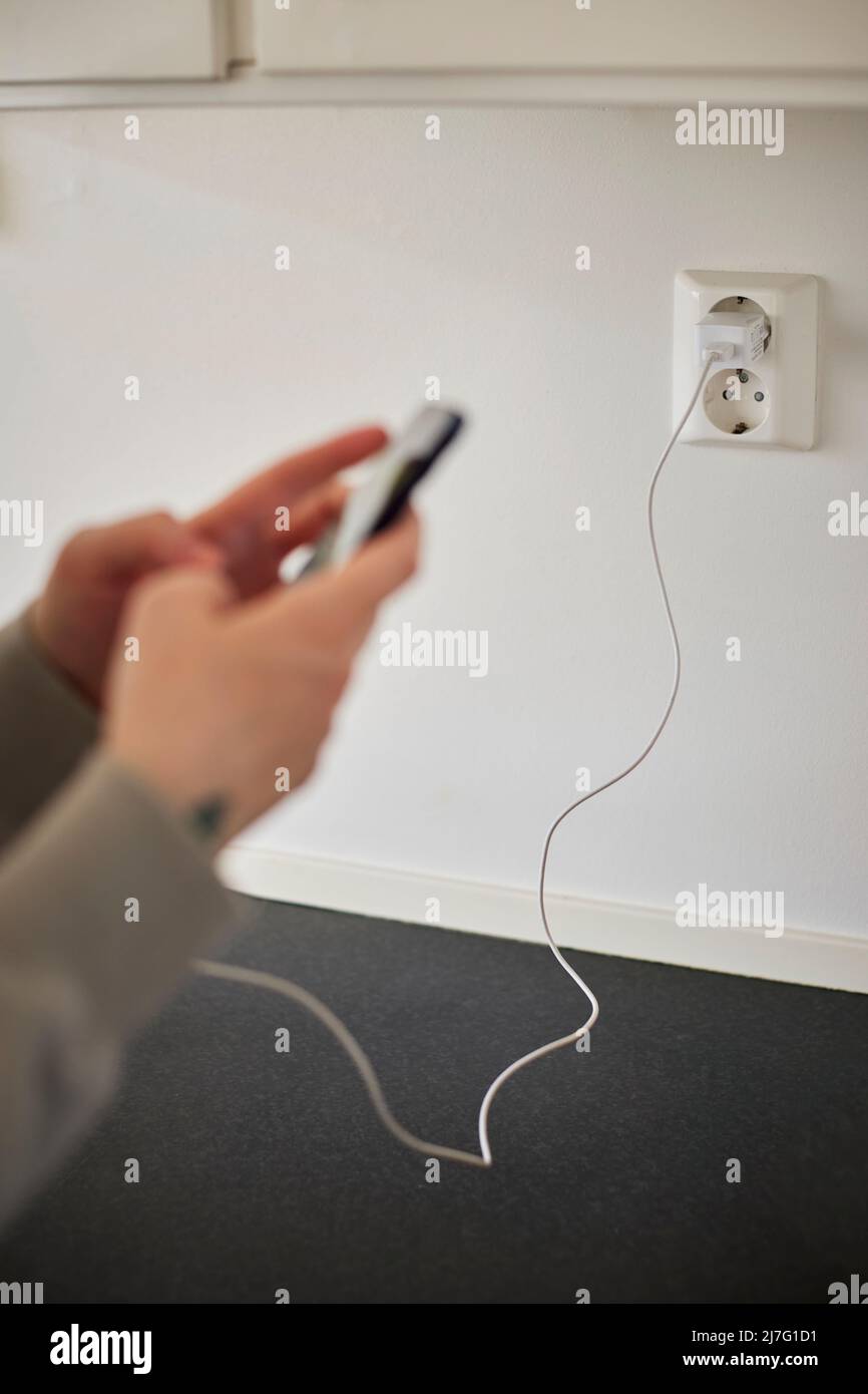 Hands holding charging cell phone Stock Photo - Alamy
