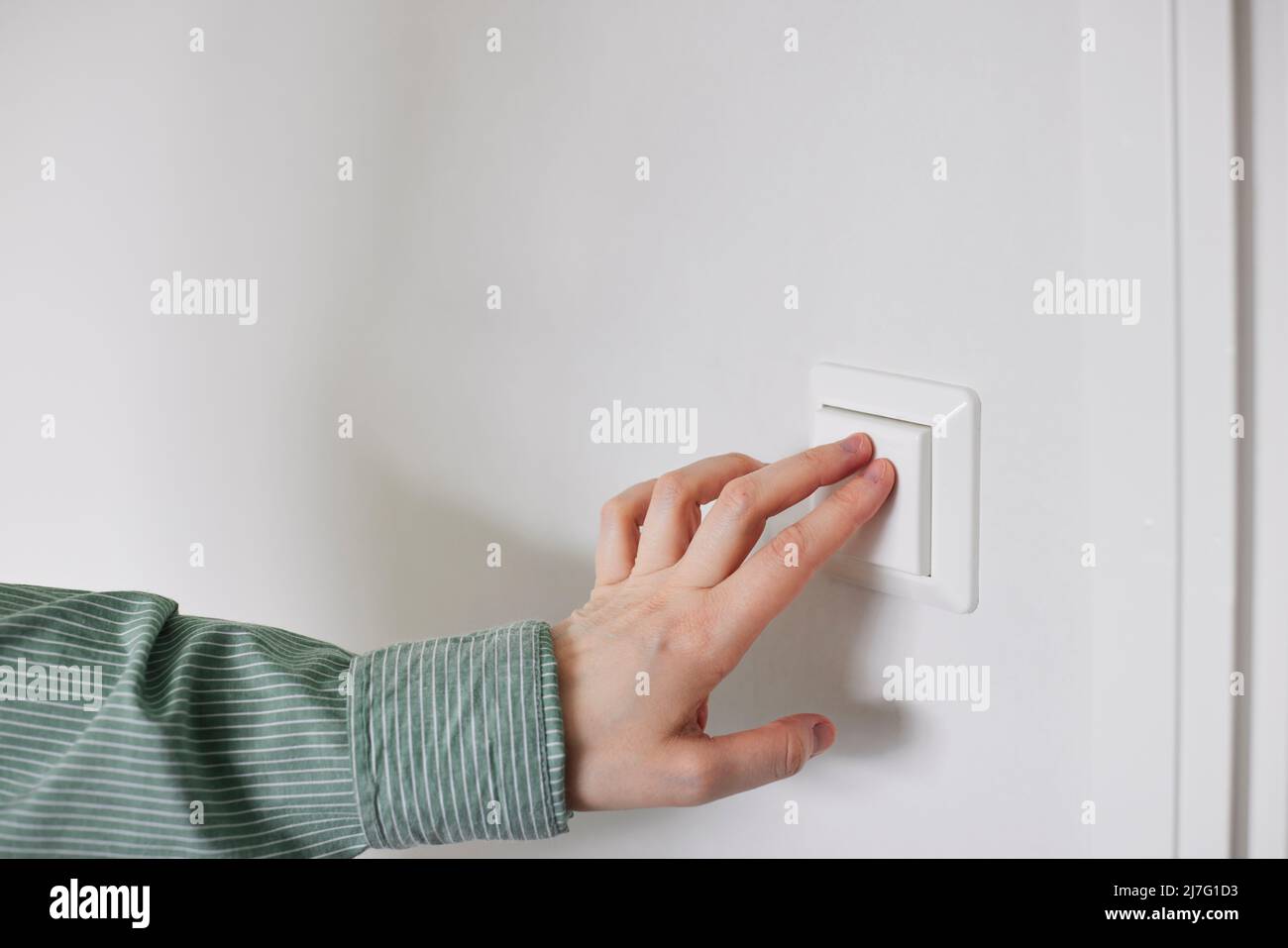 Hand pressing light switch Stock Photo - Alamy