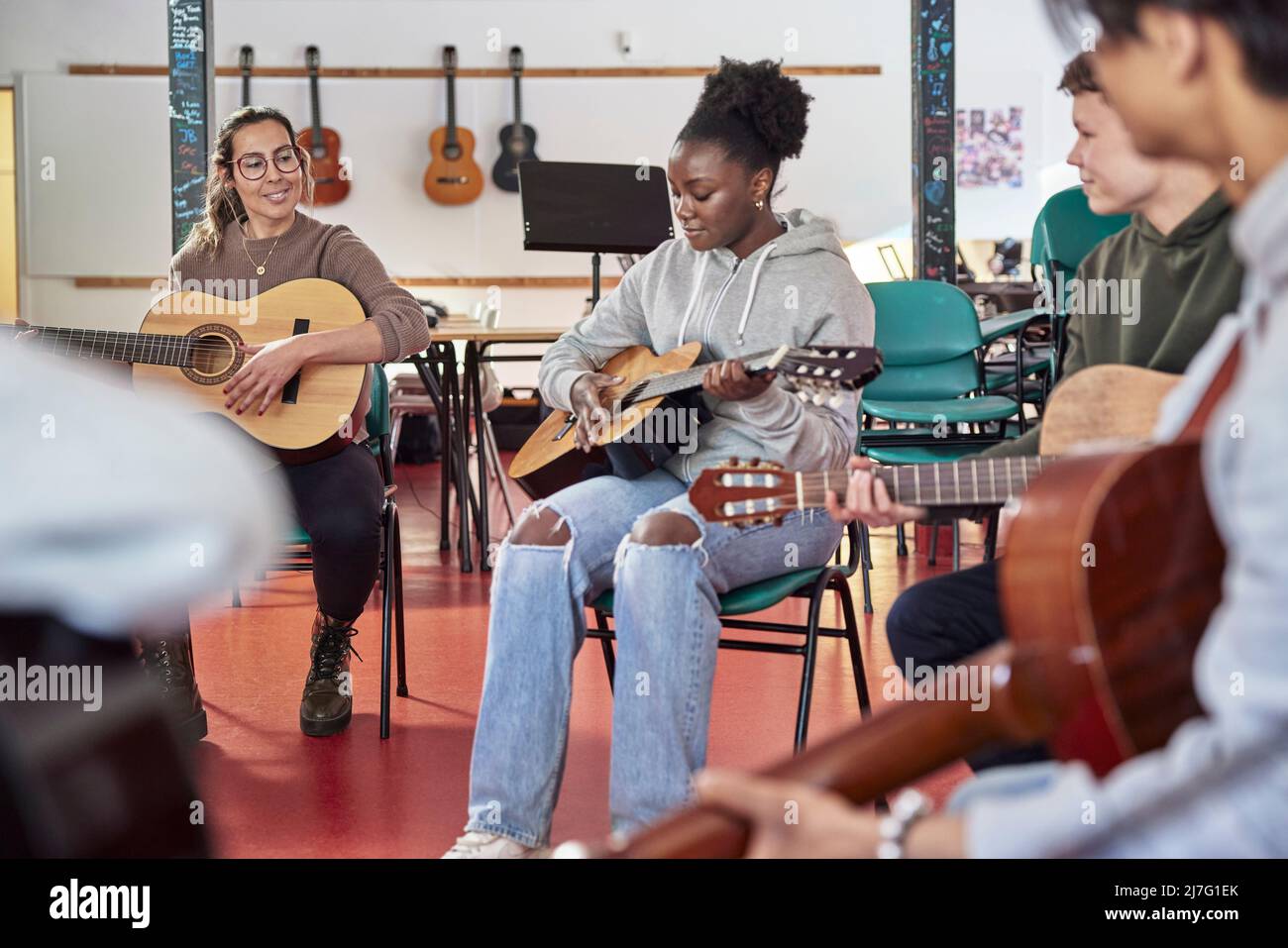 Teenagers attending guitar lesson Stock Photo - Alamy