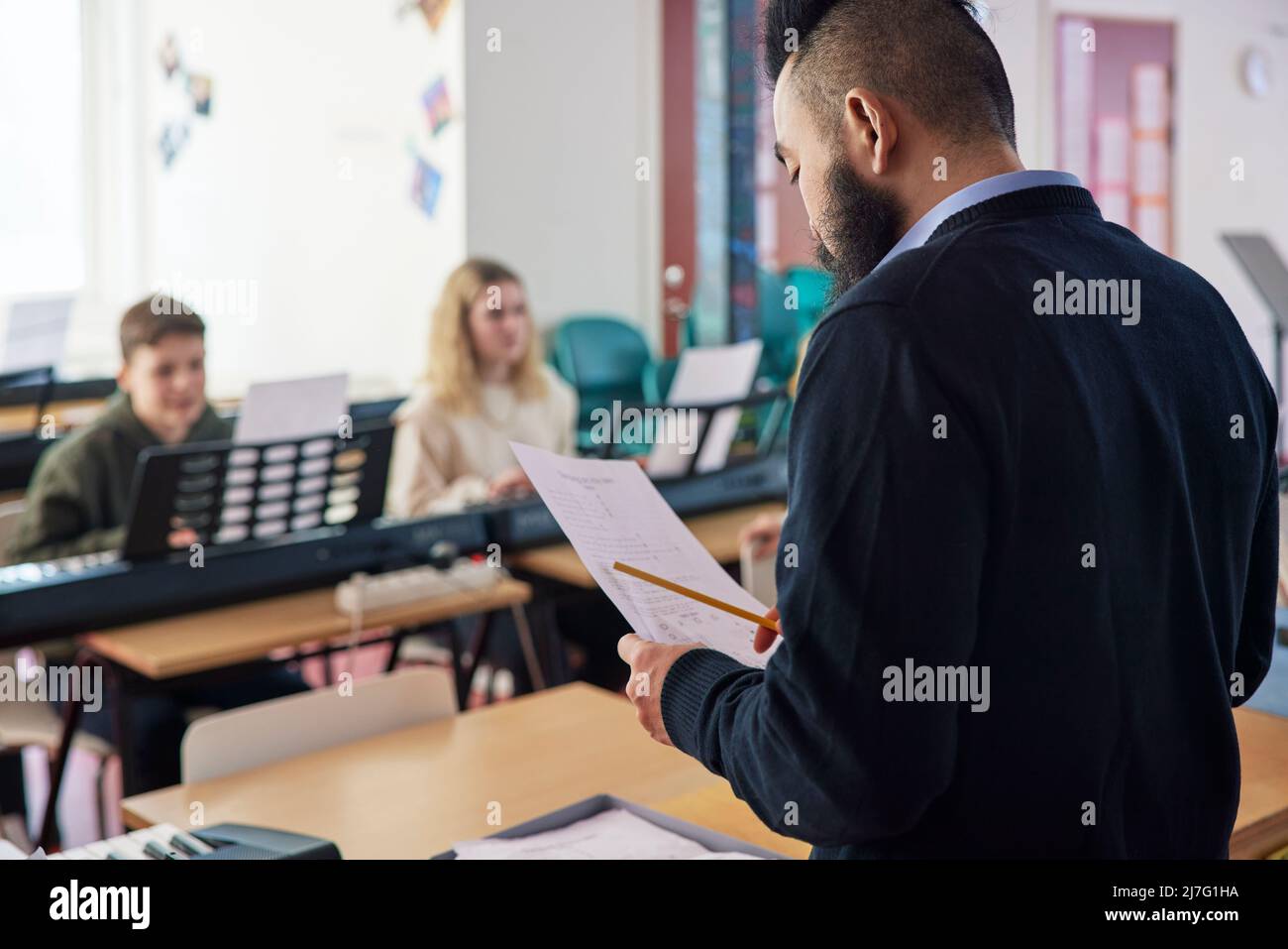Music teacher during keyboard lesson Stock Photo - Alamy