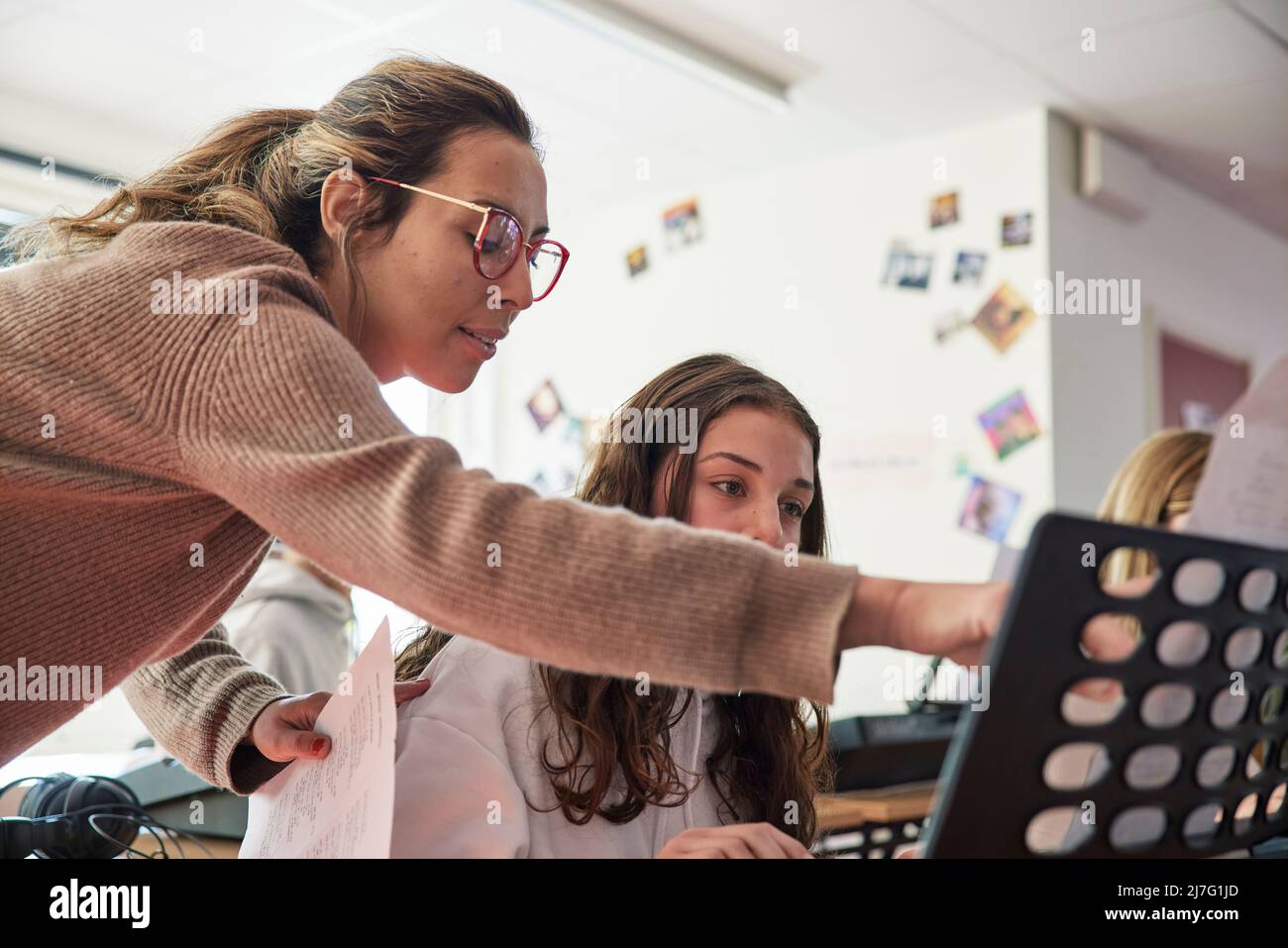 Teenage girl and teacher during keyboard lesson Stock Photo - Alamy