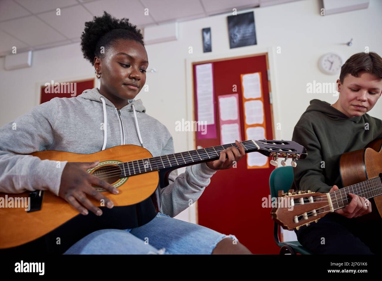 Teenagers attending guitar lesson Stock Photo - Alamy