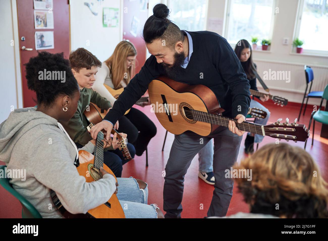 Teenagers attending guitar lesson Stock Photo - Alamy