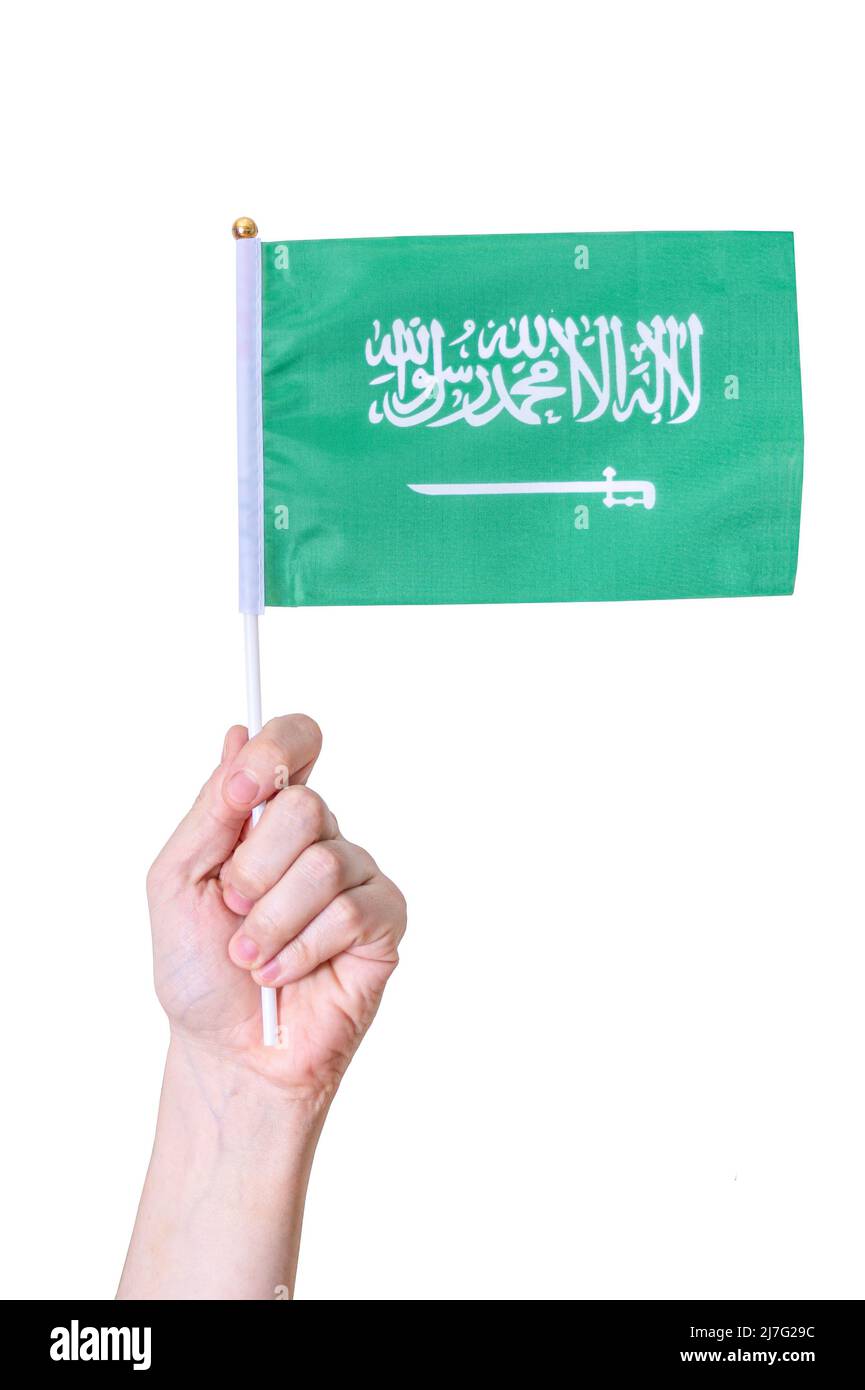 A hand holds the flag of the country of Saudi Arabia. on a white ...