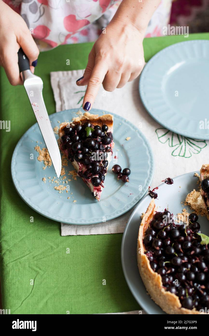 Berry sand pie: the girl slicing the cake and spreads the pieces on the ...