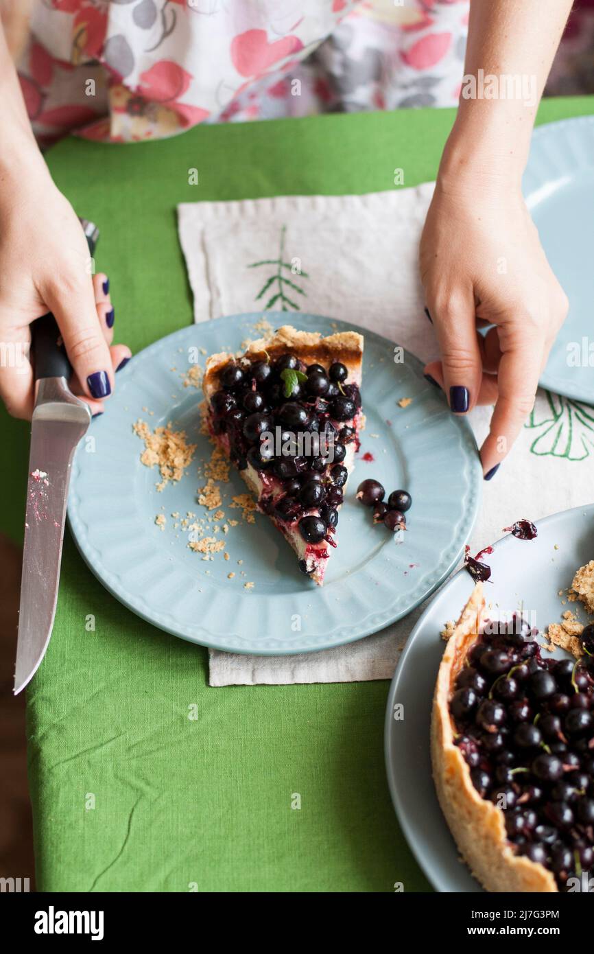 Berry sand pie: the girl slicing the cake and spreads the pieces on the ...