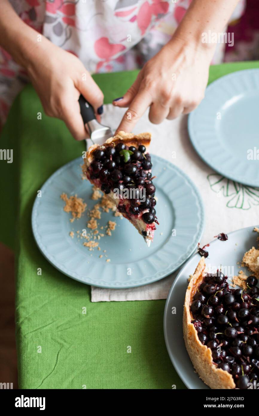 Berry sand pie: the girl slicing the cake and spreads the pieces on the ...
