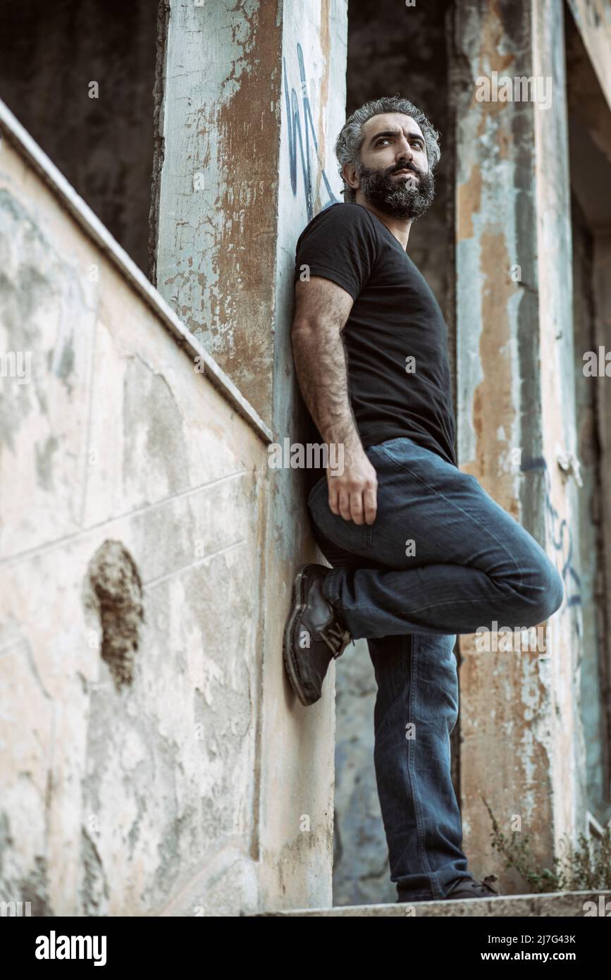 Middle Eastern man standing outside a derelict building Stock Photo - Alamy