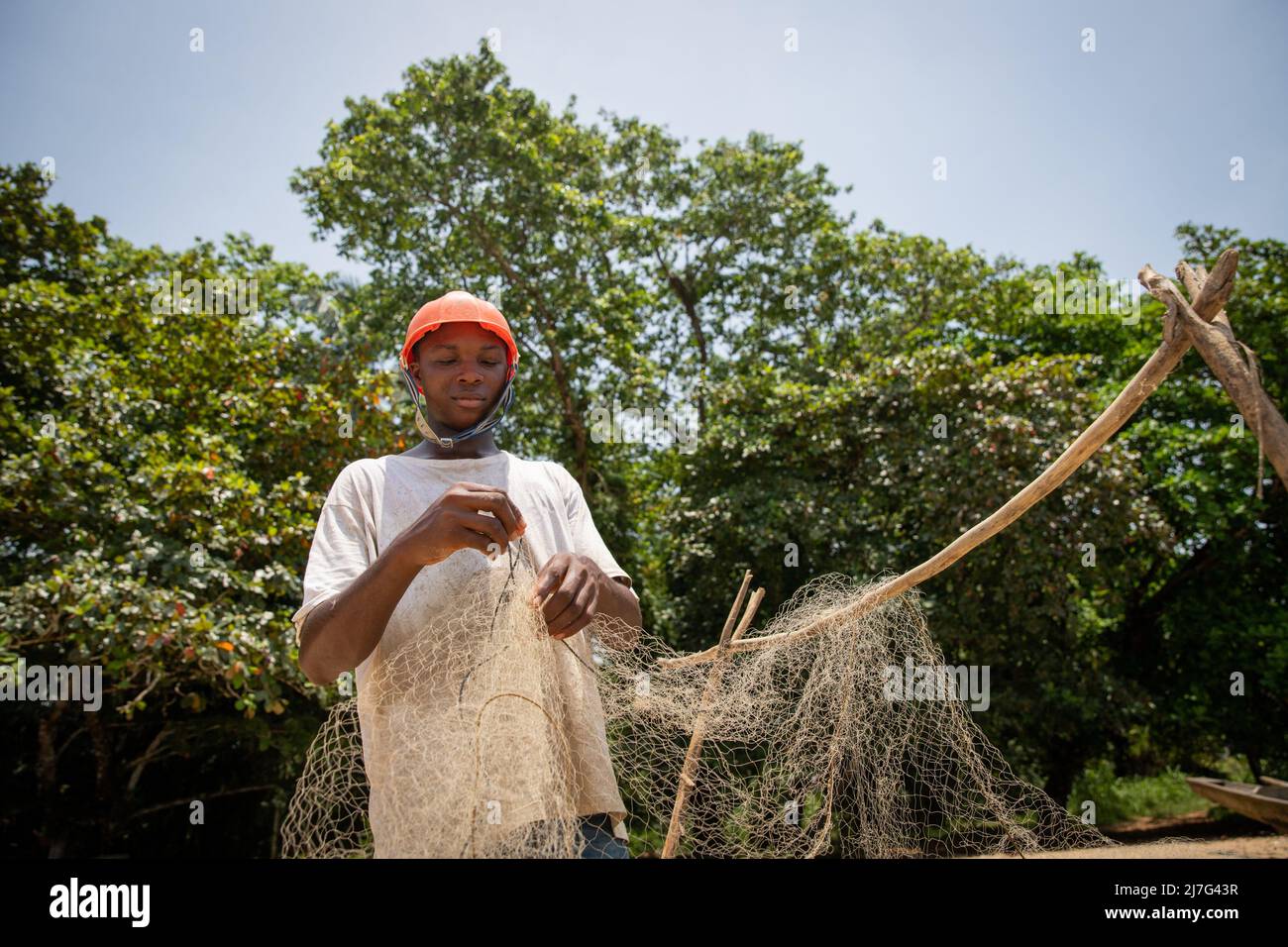 African fisherman is setting up the fishing net to go to work, person ...