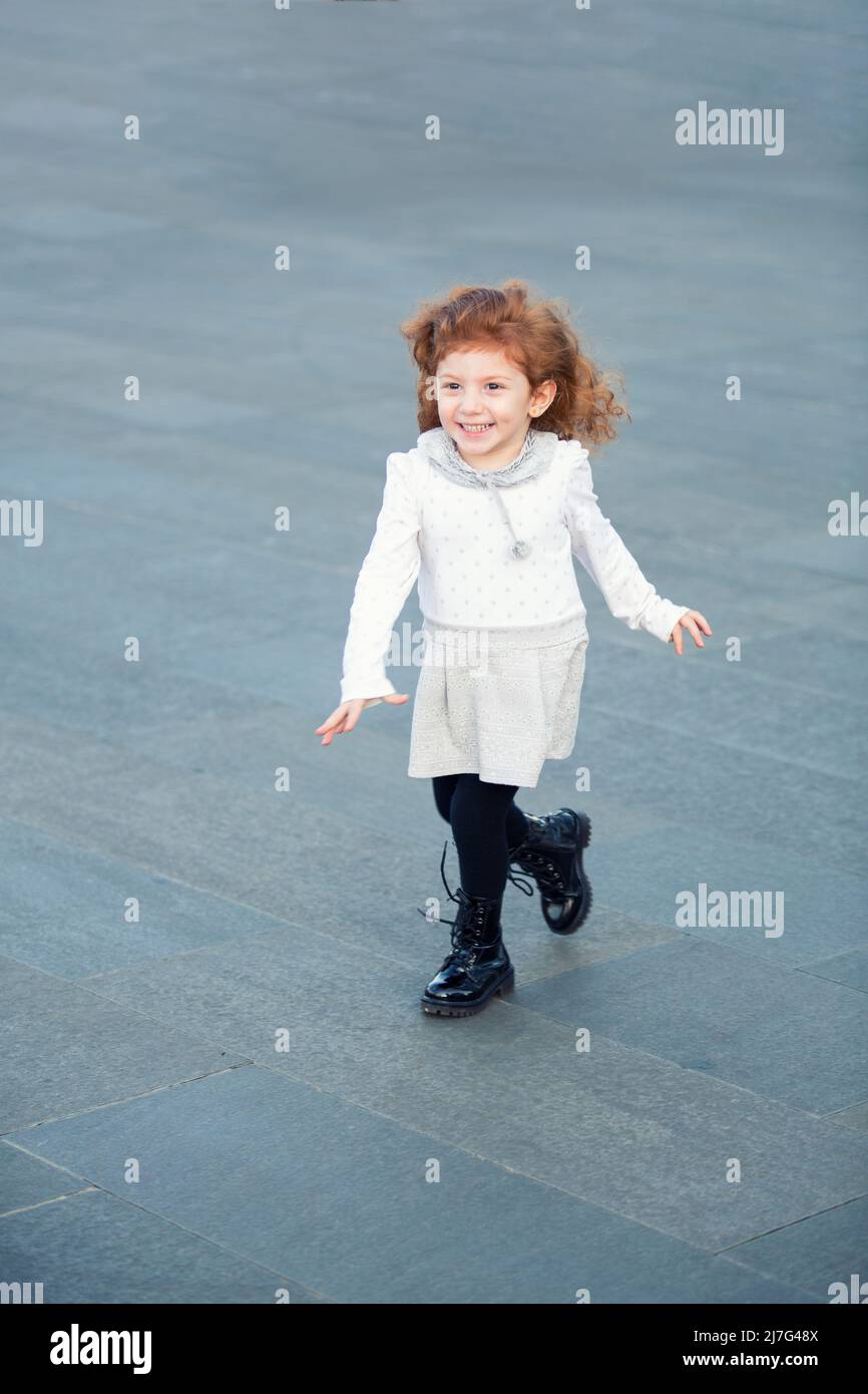 Happy little girl running outdoors Stock Photo - Alamy