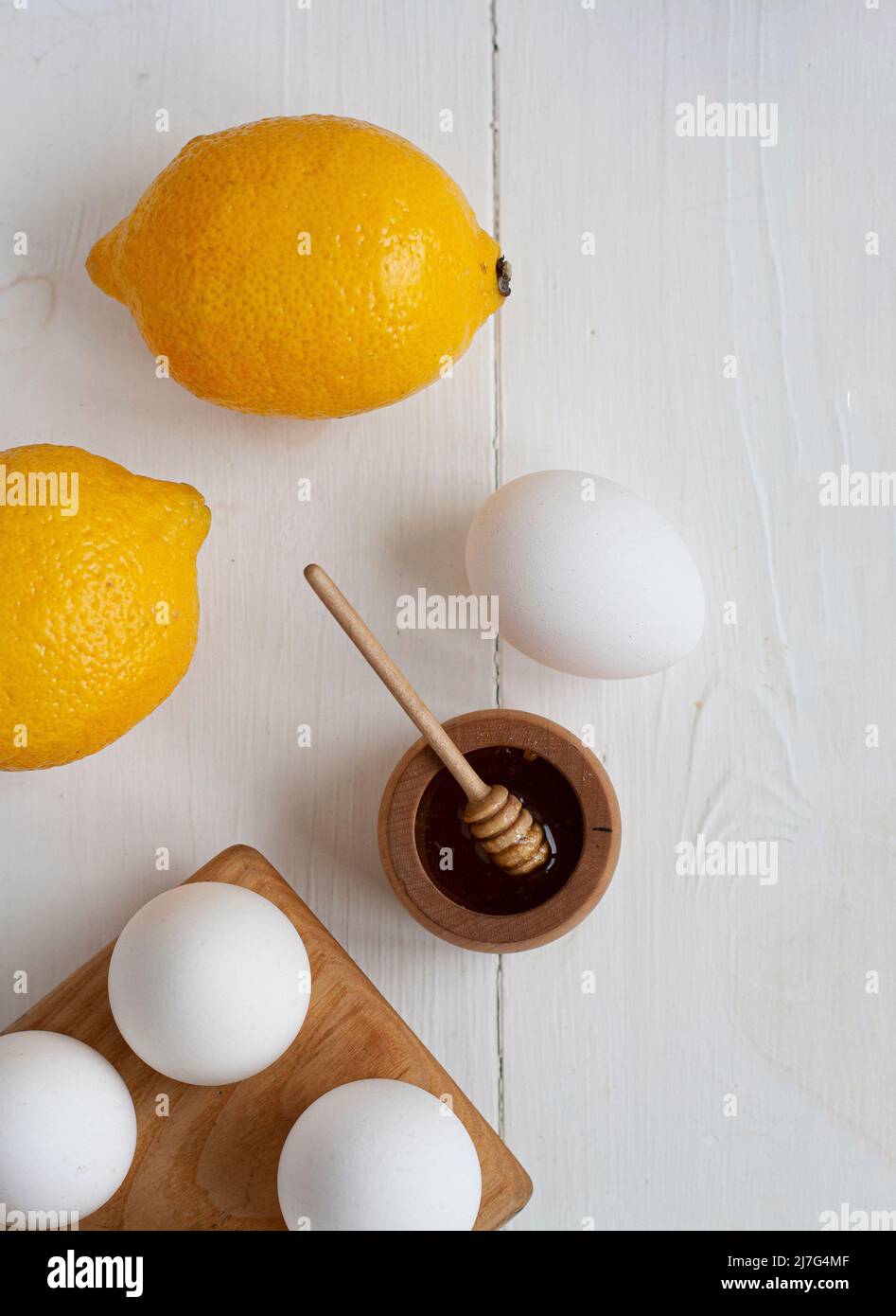 Sauce preparation: eggs, lemon . Products lie on white wooden ...