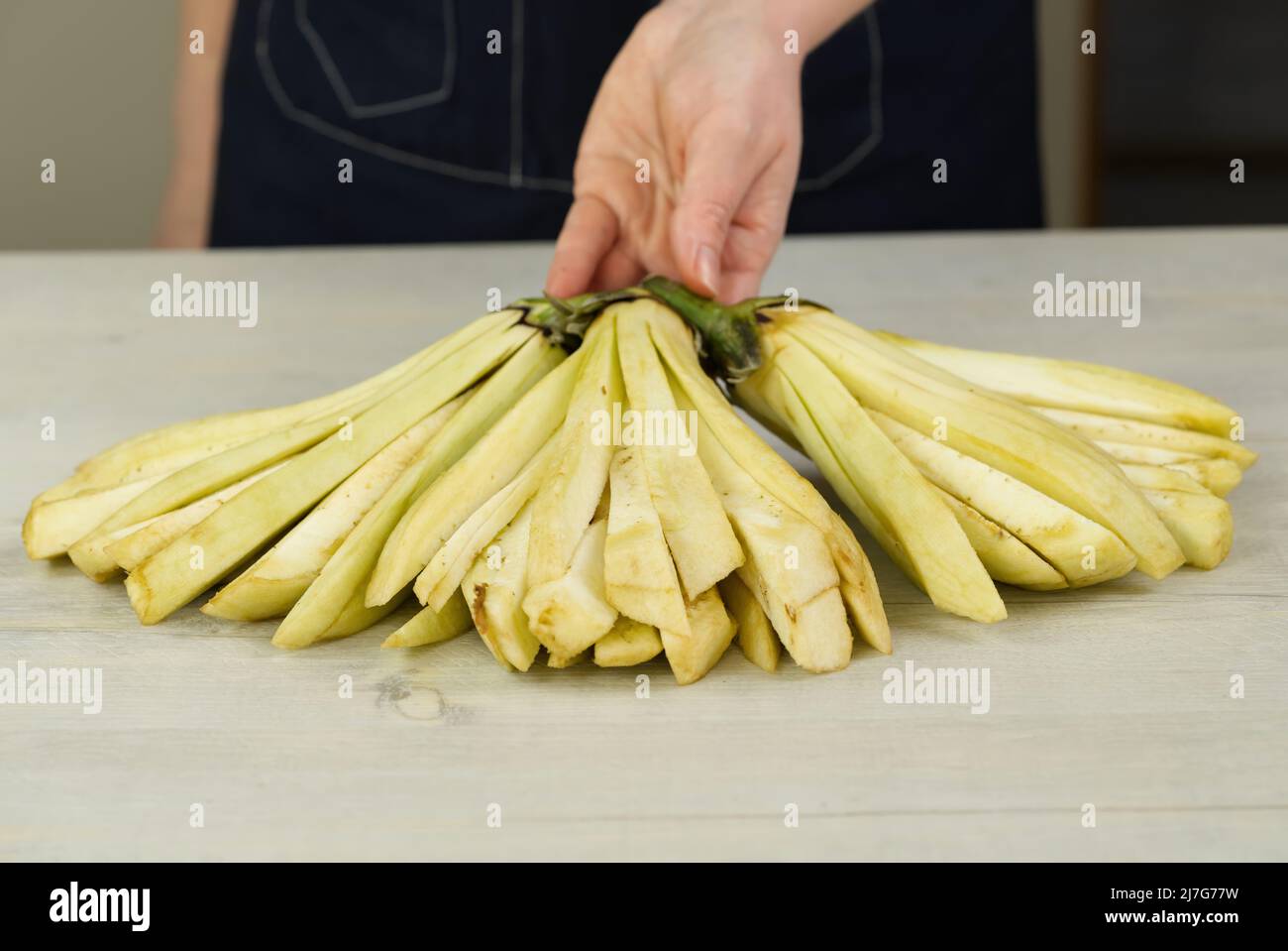 Eggplant sliced in a beautiful way. A woman holds in hand cutted ...