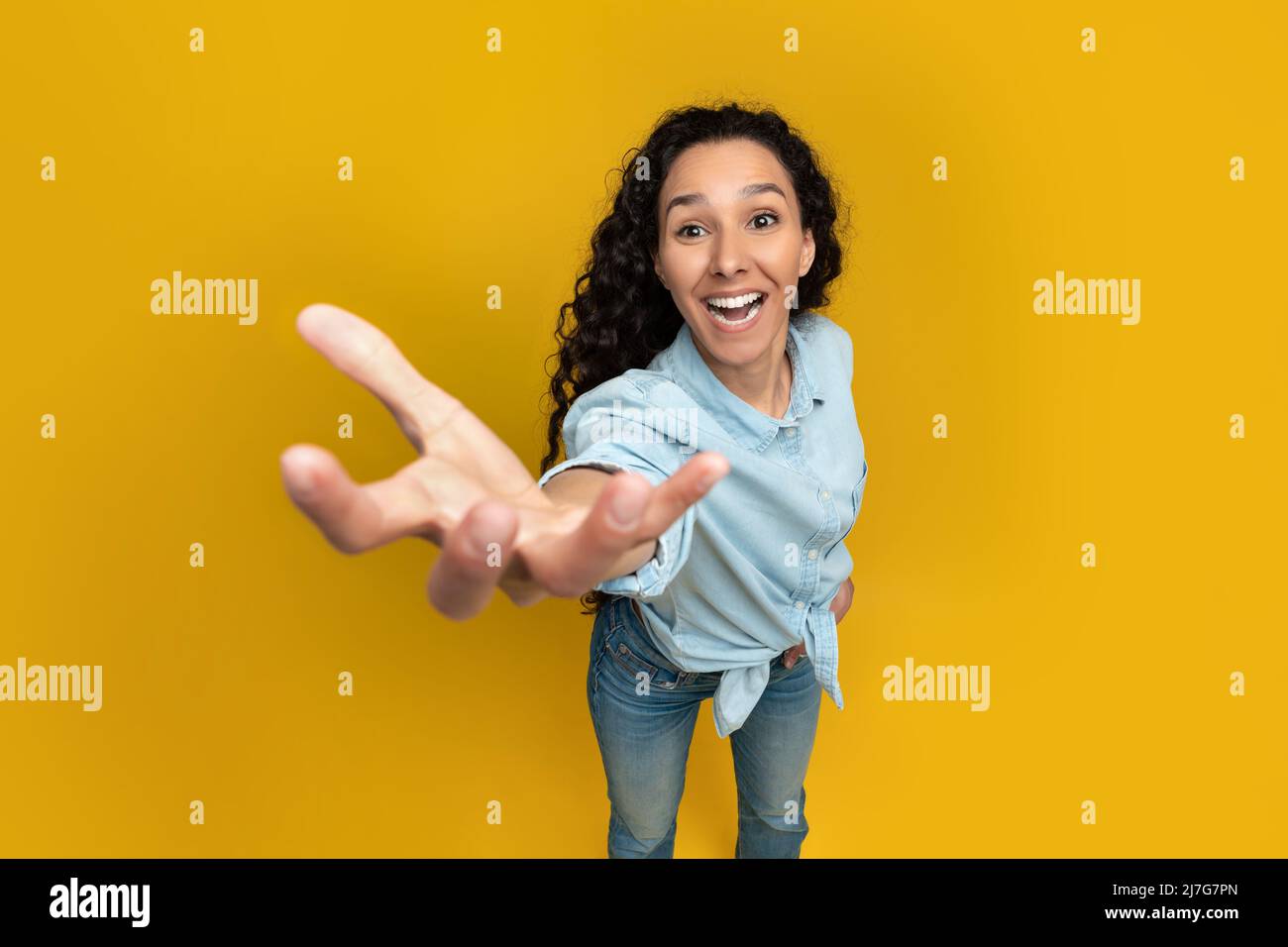Excited young woman outstretching hand, trying to grab something Stock ...