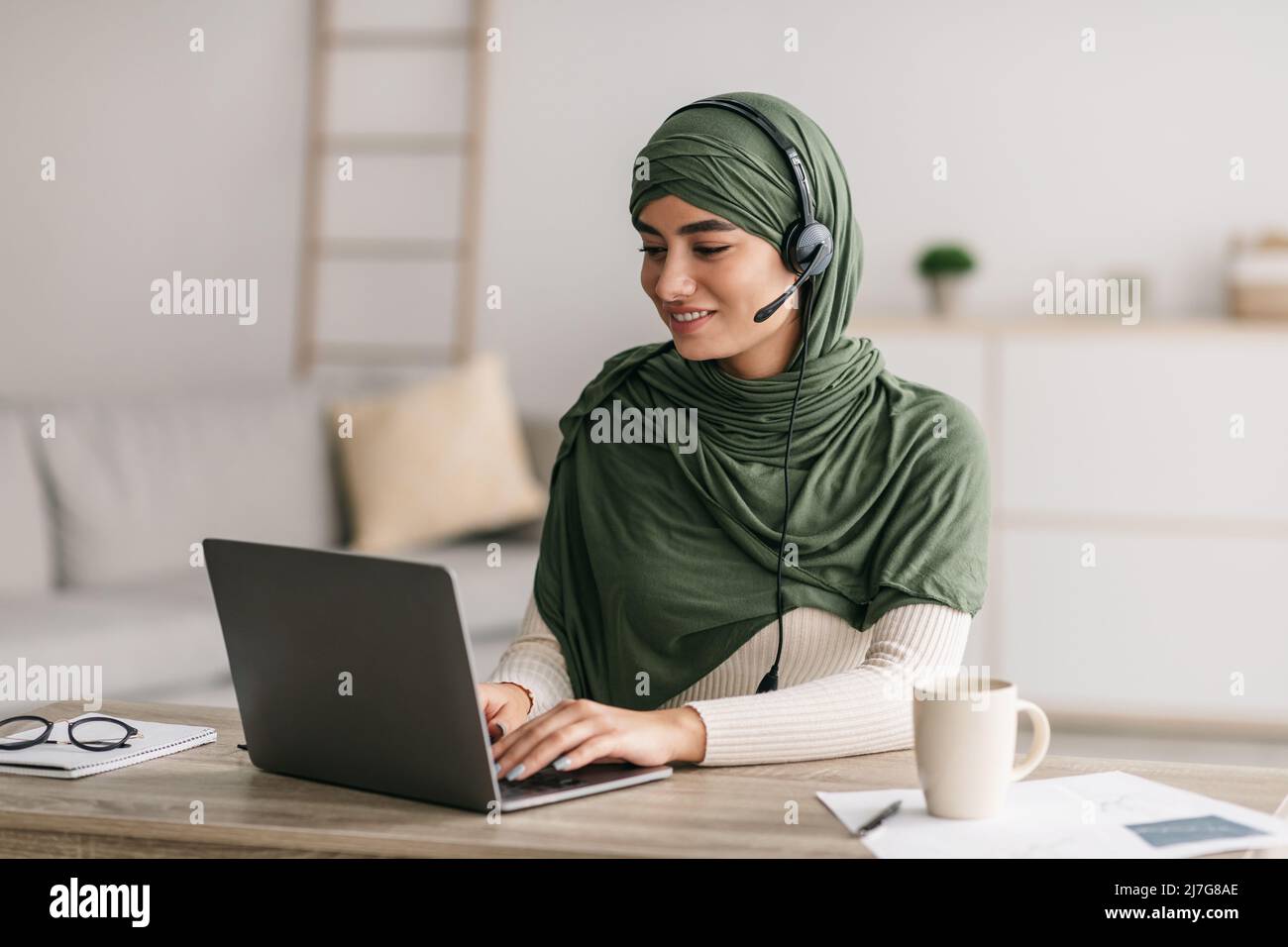 Freelance job, online meeting. Young Arab lady in hijab using laptop ...