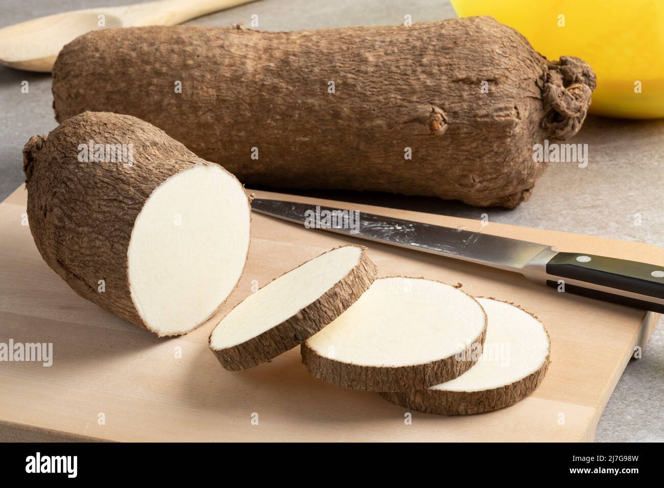 Whole and sliced raw African yam close up on a cutting board Stock ...