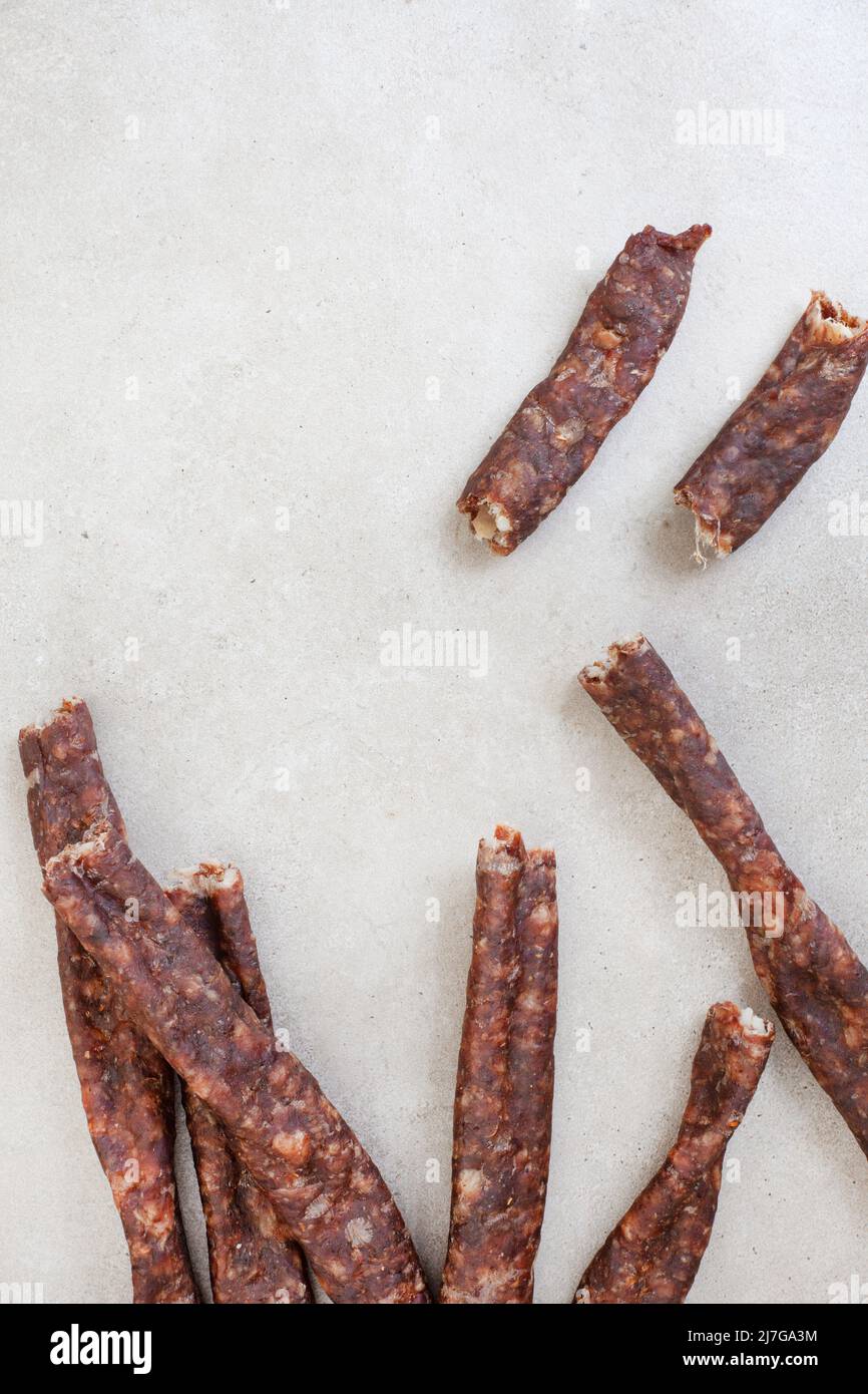 South African Dry Wors, a dried and cured sausage snack on grey, with ...