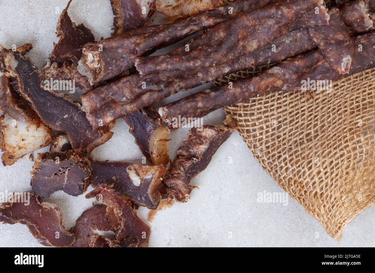 South African Dry Wors, a dried and cured sausage snack on grey, with ...