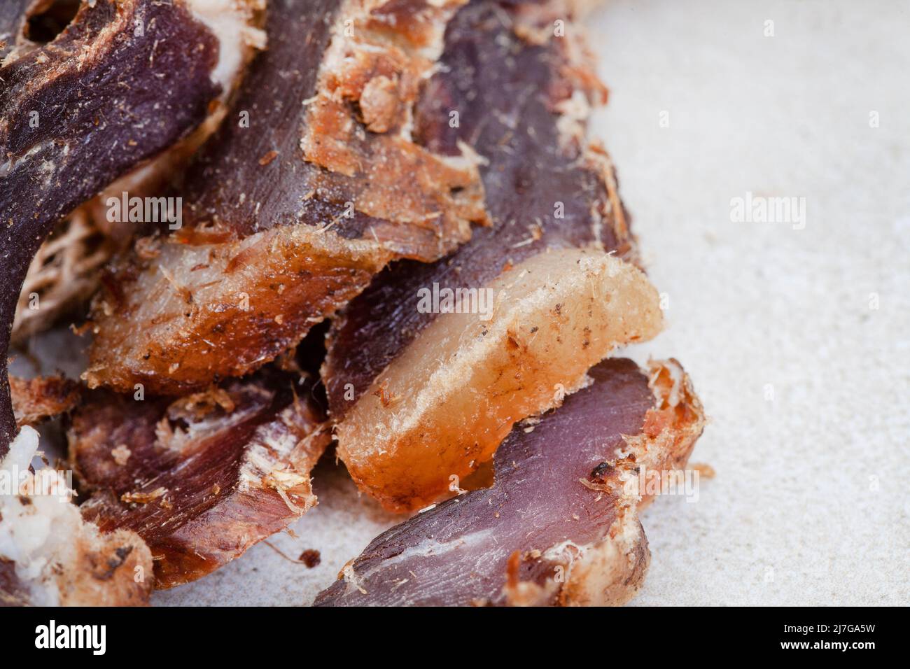 South African Biltong, a dried and cured meat sliced and on grey ...