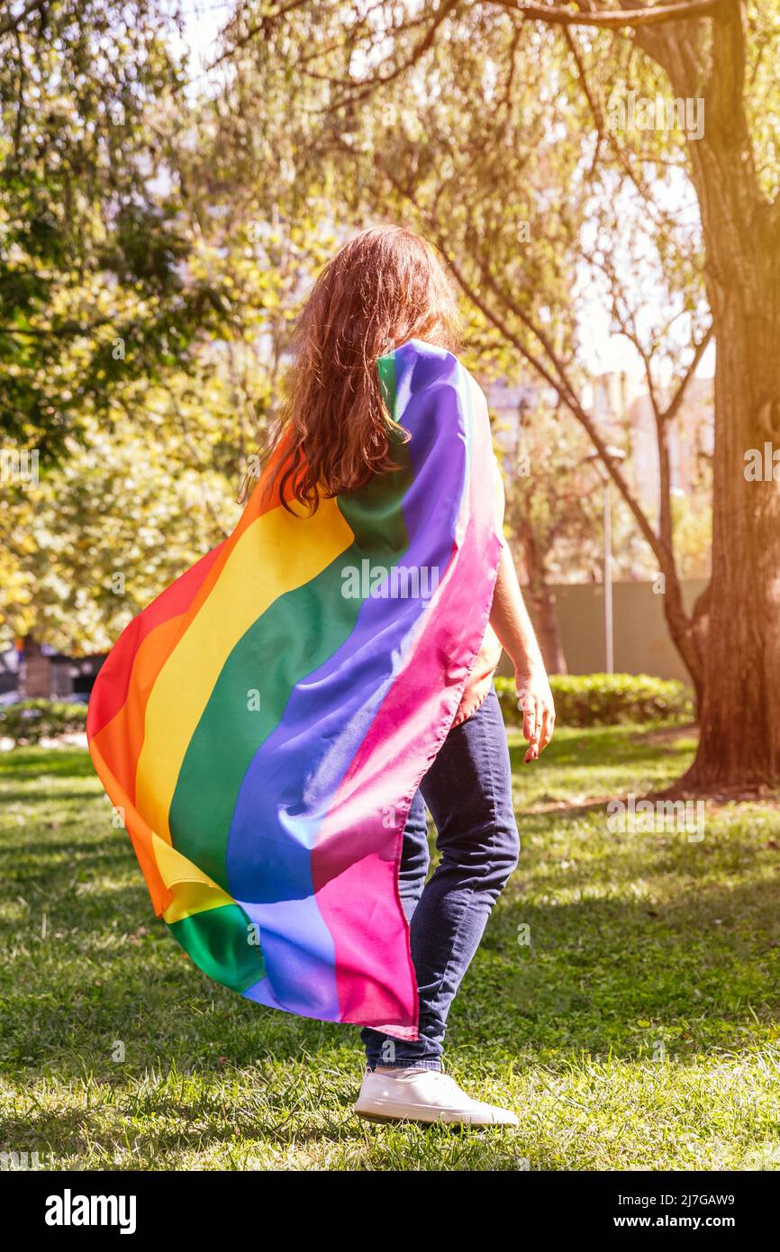 Young woman wearing an LGBTQ rainbow flag, symbol for the homosexual ...