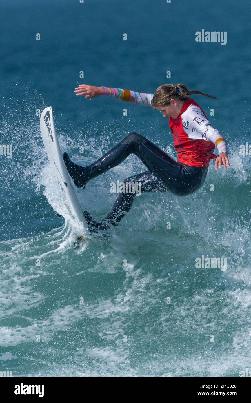 A female; surfer competing in a surfing competition at Fistral in ...