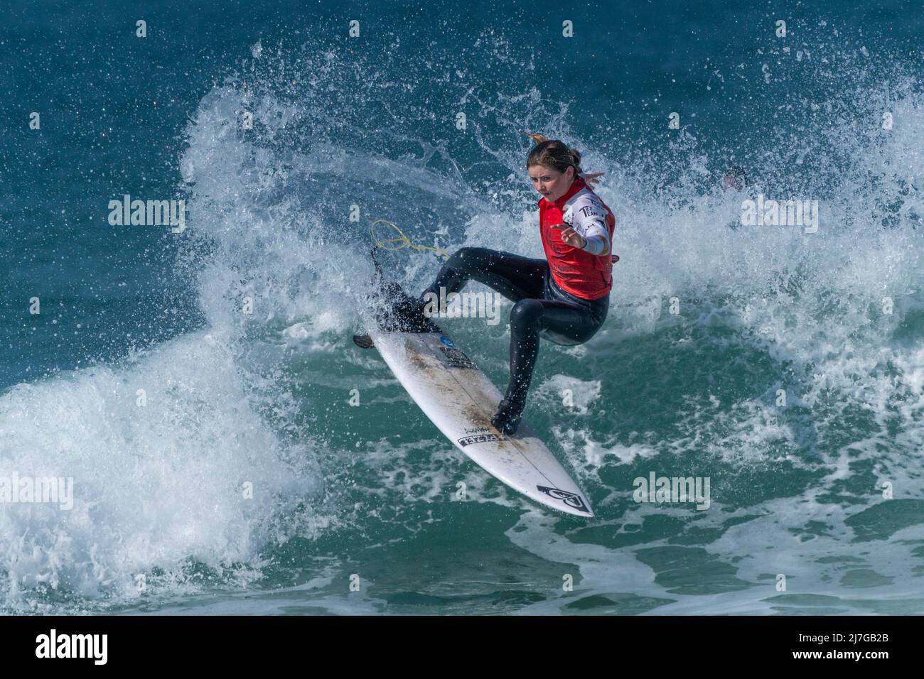 A female surfer competing in a surfing competition at Fistral in ...