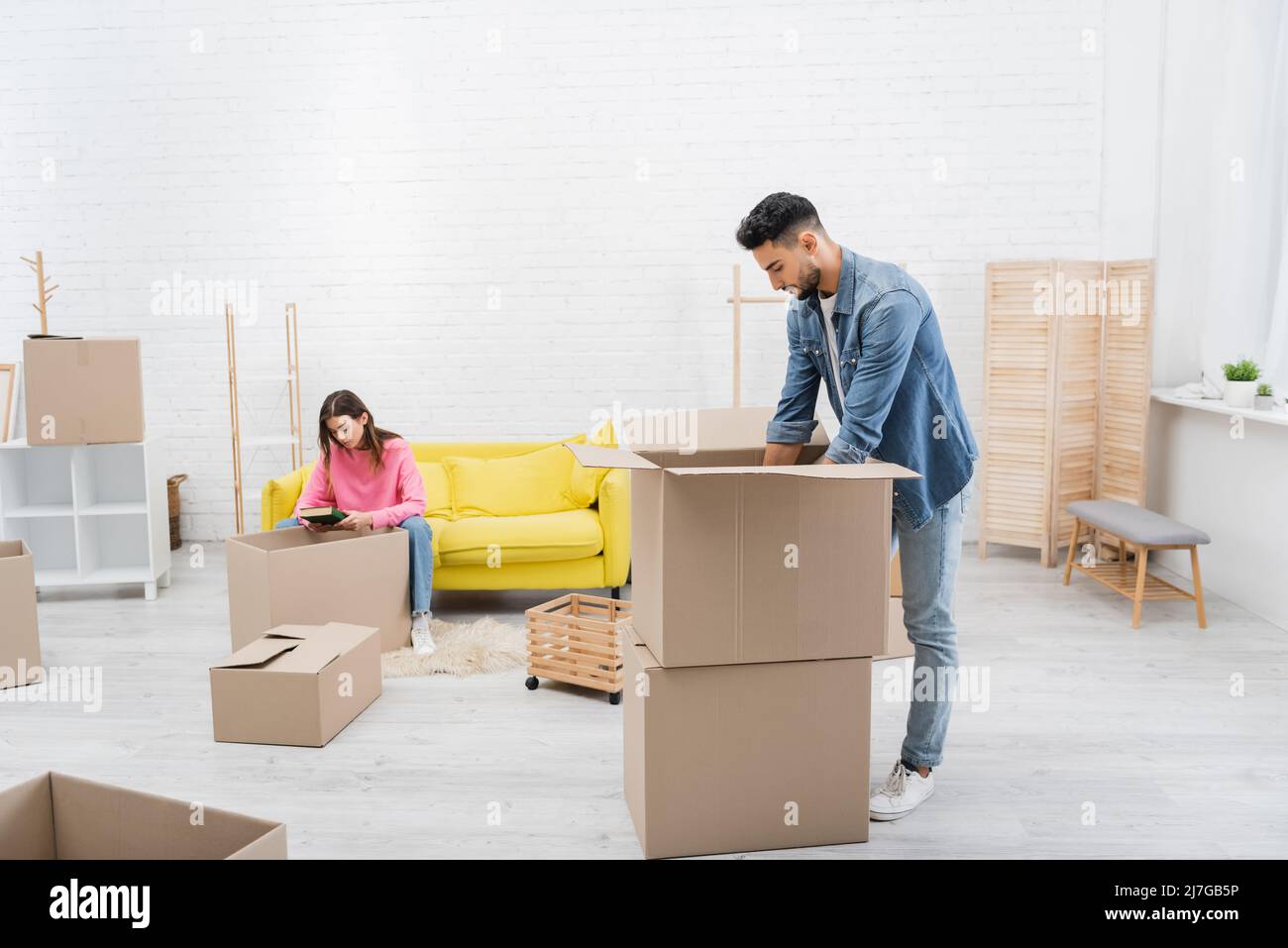 Muslim man standing near carton boxes at home Stock Photo - Alamy