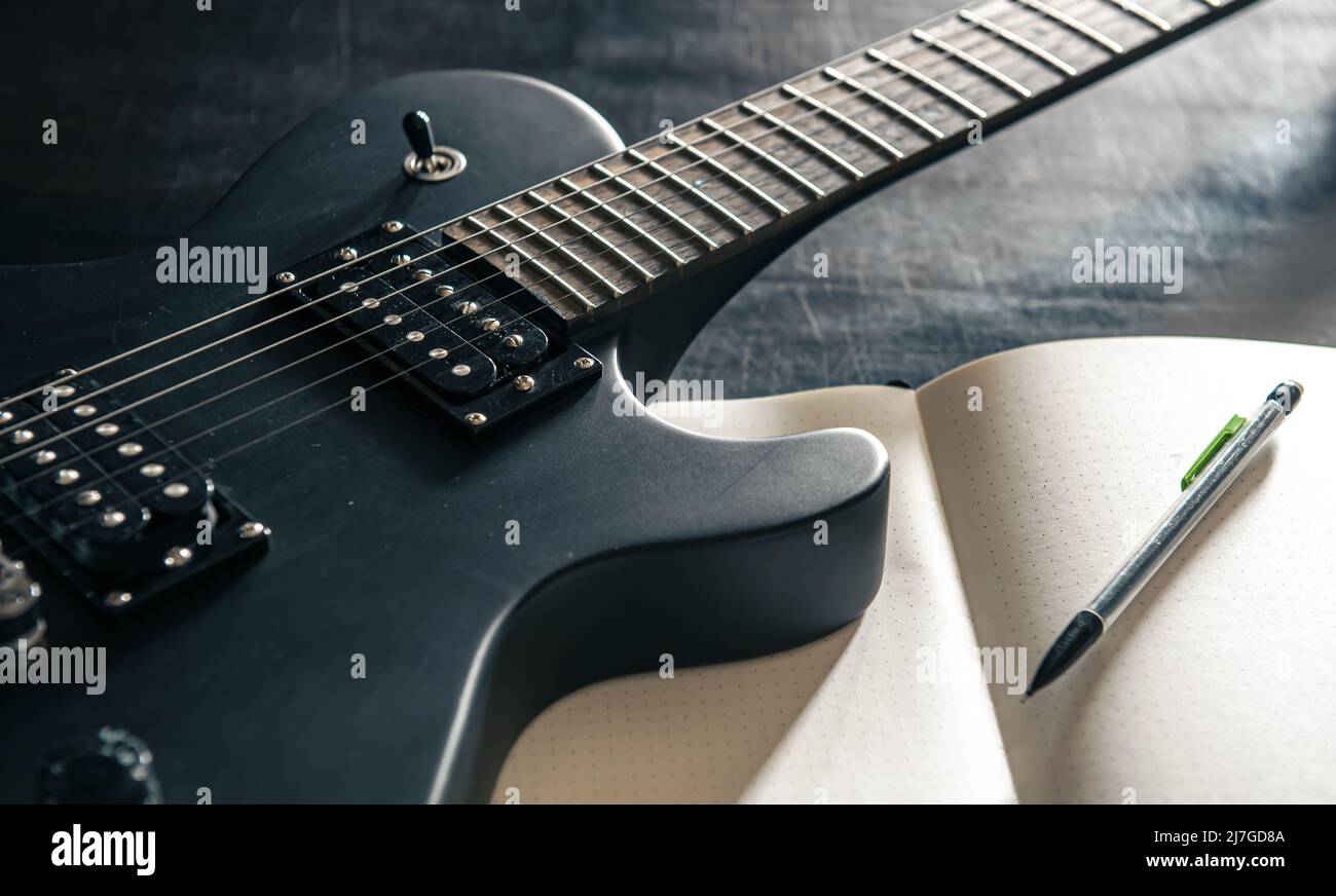 Close-up, electric guitar and notepad, concept of musical creativity ...