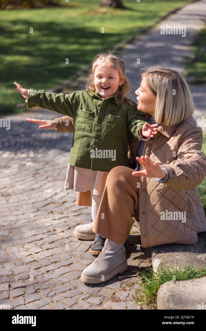 excited mother and daughter with outstretched hands having fun in park Stock Photo - Alamy