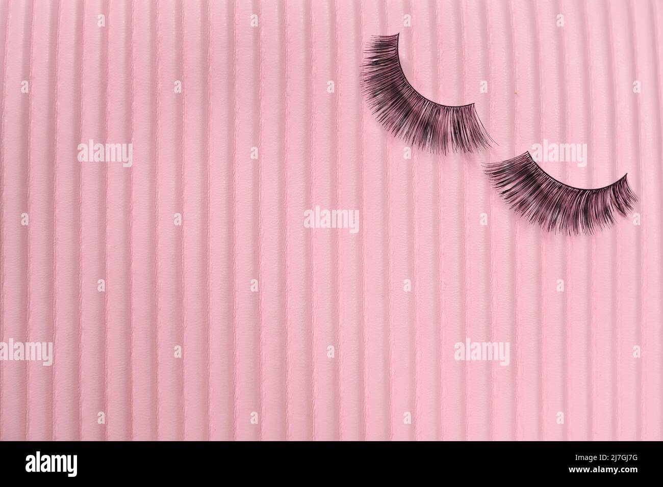 Fake lashes on pink background copy space Stock Photo - Alamy