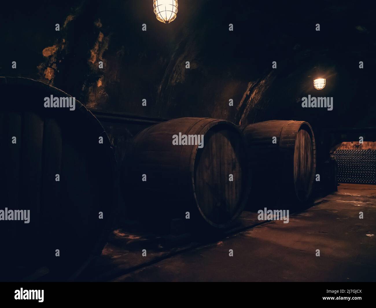 Big wooden barrels in dark underground cellar. Winemaking and winery ...