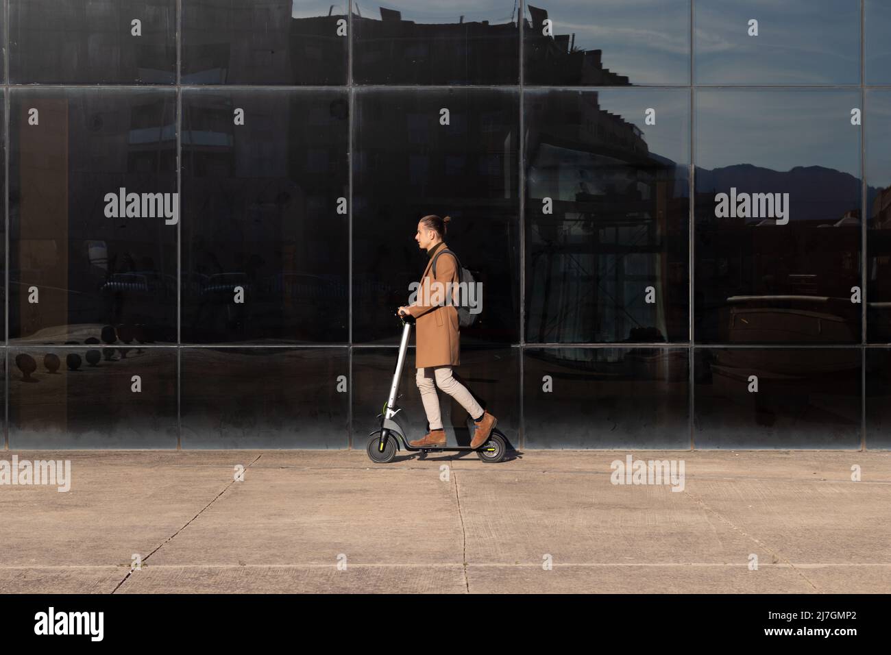 Side view of young man commuting to office work in a big city with ...