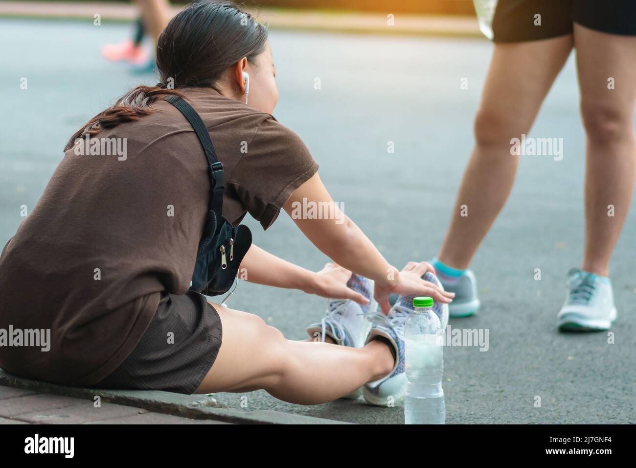 Back view of young woman runner wear earbuds sit to relax on the ...