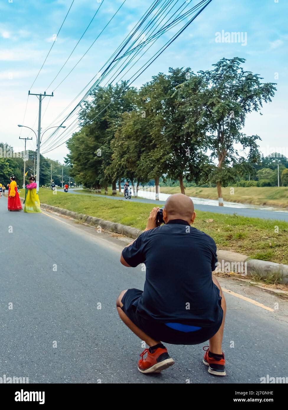 Back view of Asian sport photographer with camera sit to take picture ...