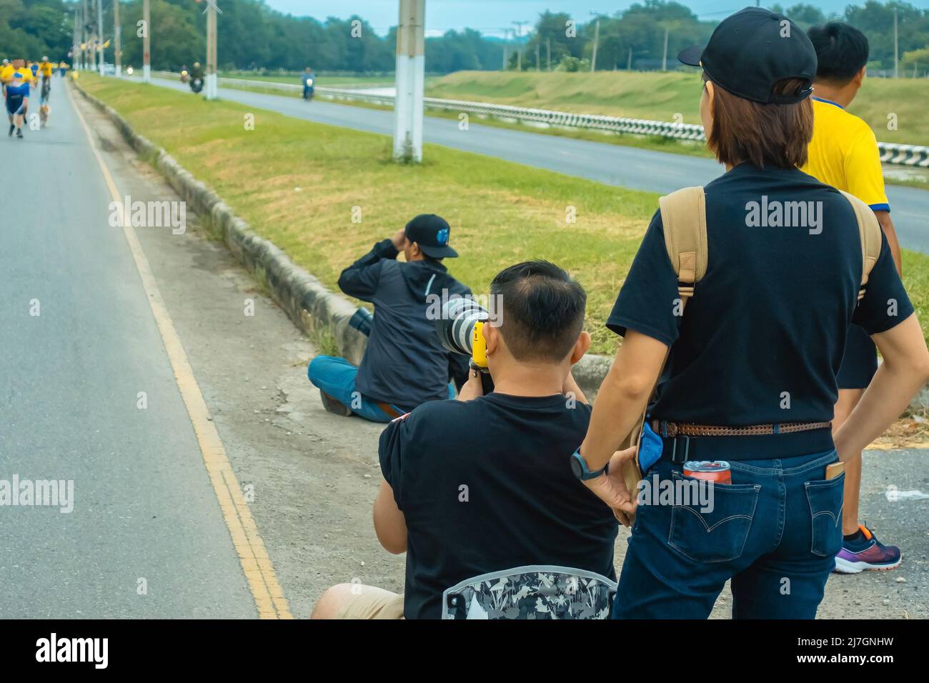 Back view of Asian sport photographer with camera sit to take picture ...