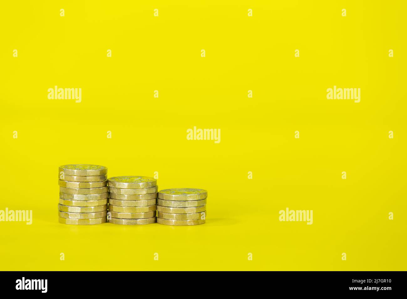 Gold coloured UK GBP Pounds Sterling one pound coins in stacks ...