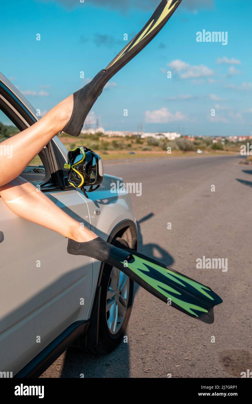 woman legs in flippers stick out from the car window sea vacation ...