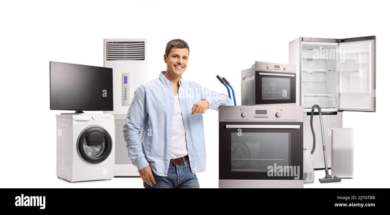 Young man posing with an oven and other electrical appliances isolated ...