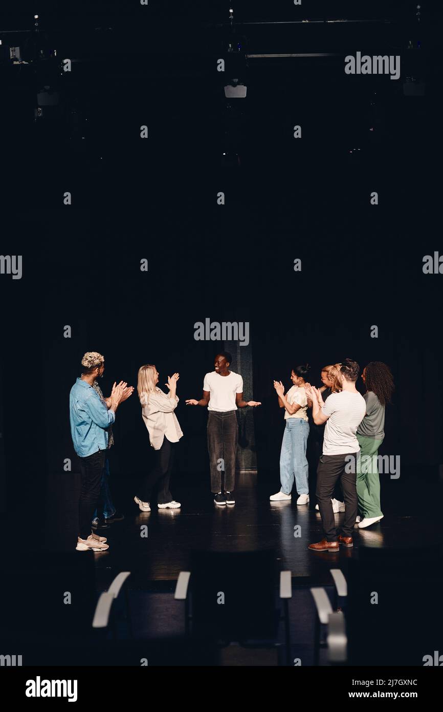 Multiracial male and female stage performers applauding actor in class ...