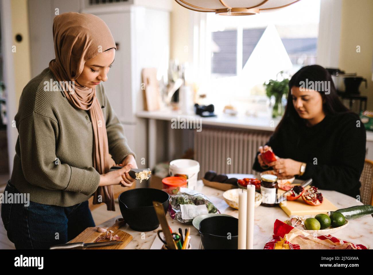 Young women preparing food in kitchen at home Stock Photo - Alamy