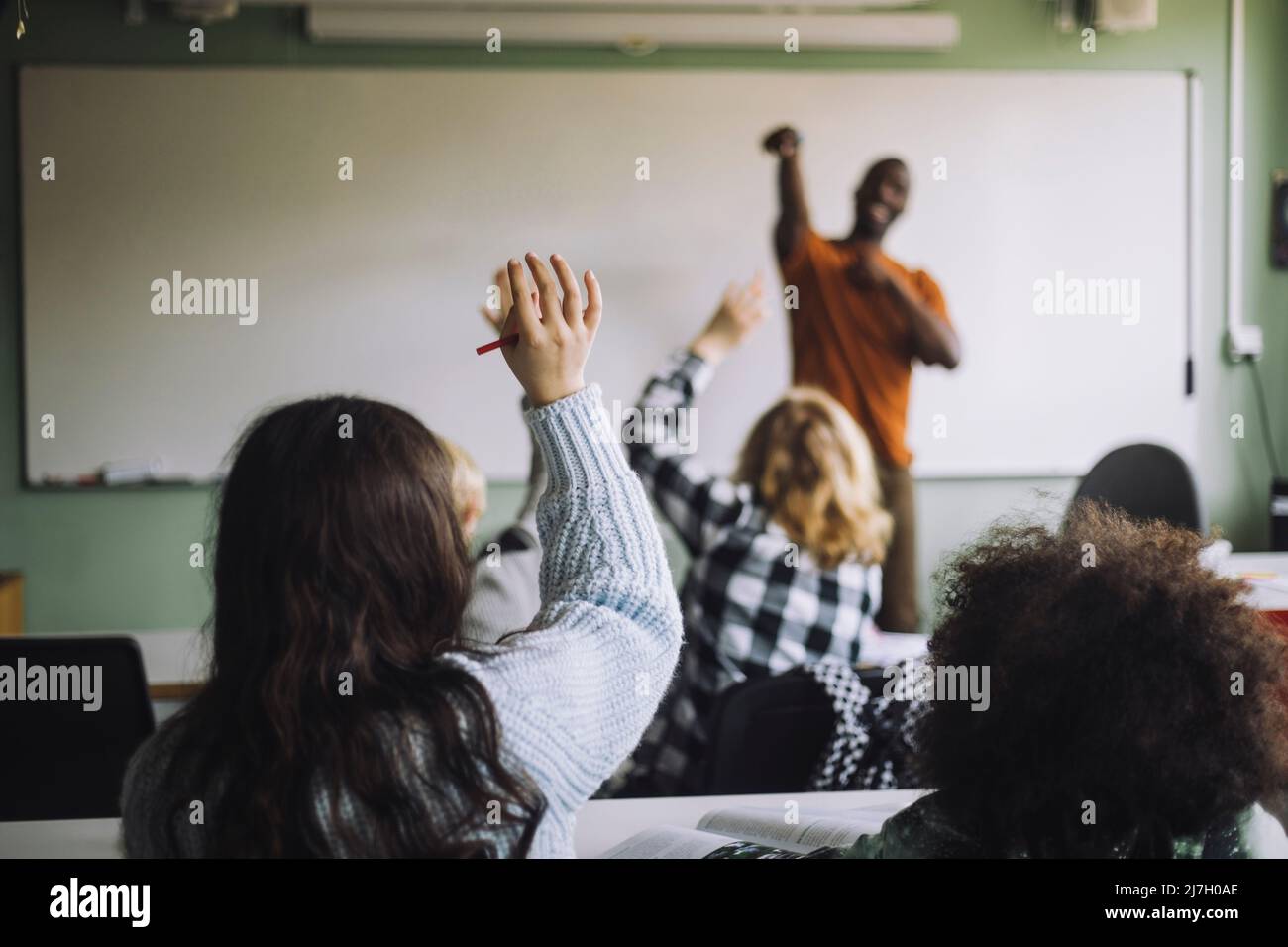 Back view schoolgirl raising hand hi-res stock photography and images ...