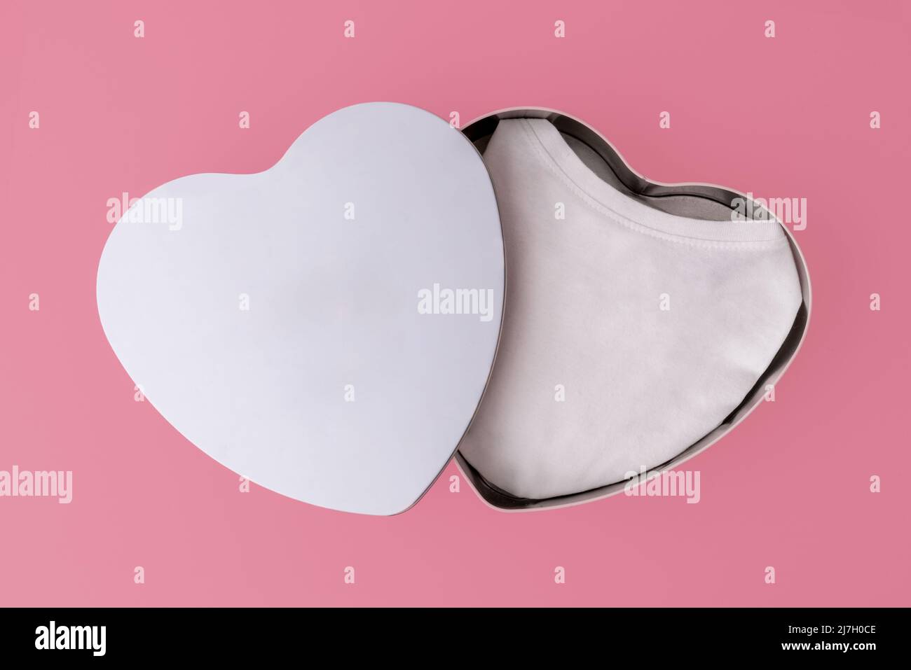 Mock-up of a white T-shirt inside a heart-shaped box on a pink ...