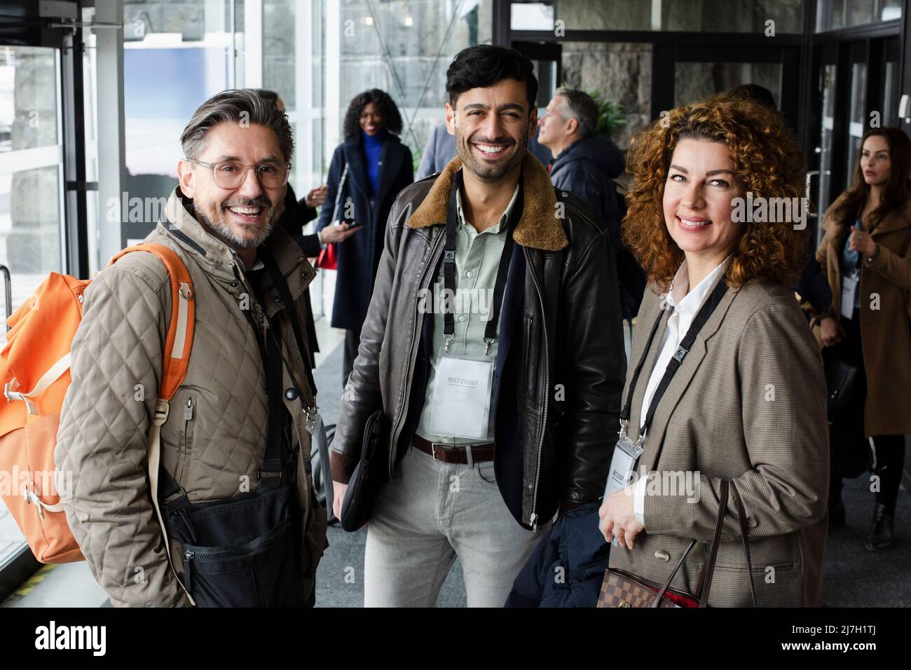 Portrait of business delegates standing in lobby during seminar at ...