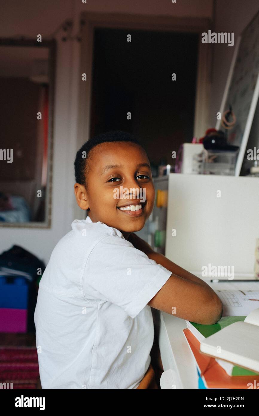 Portrait of boy sitting at table in study room at home Stock Photo - Alamy