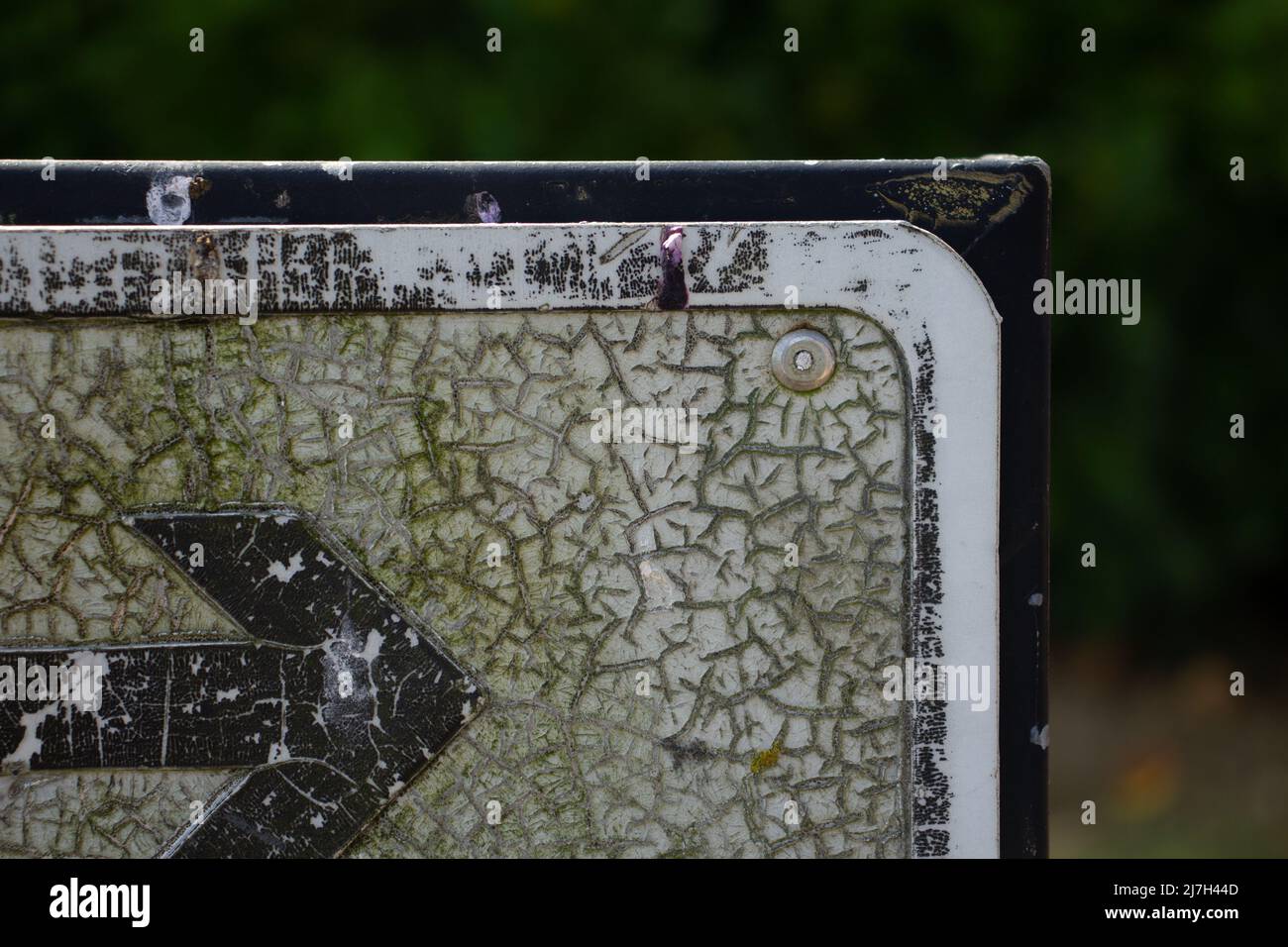 detail of a cracked and old corner edge of a directional sign with ...