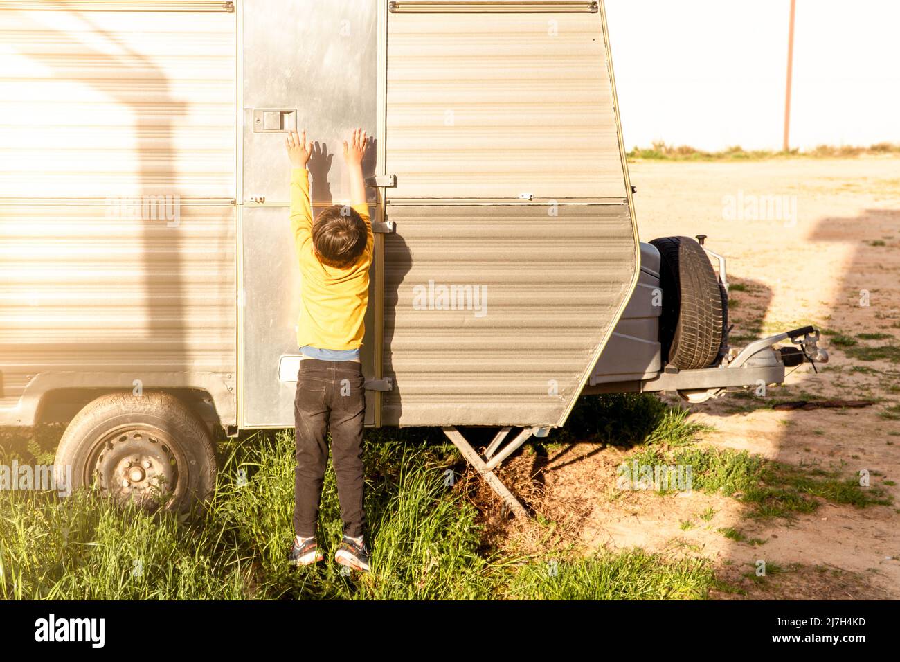 little boy sitted on the outside of a vintage holiday caravan Stock ...